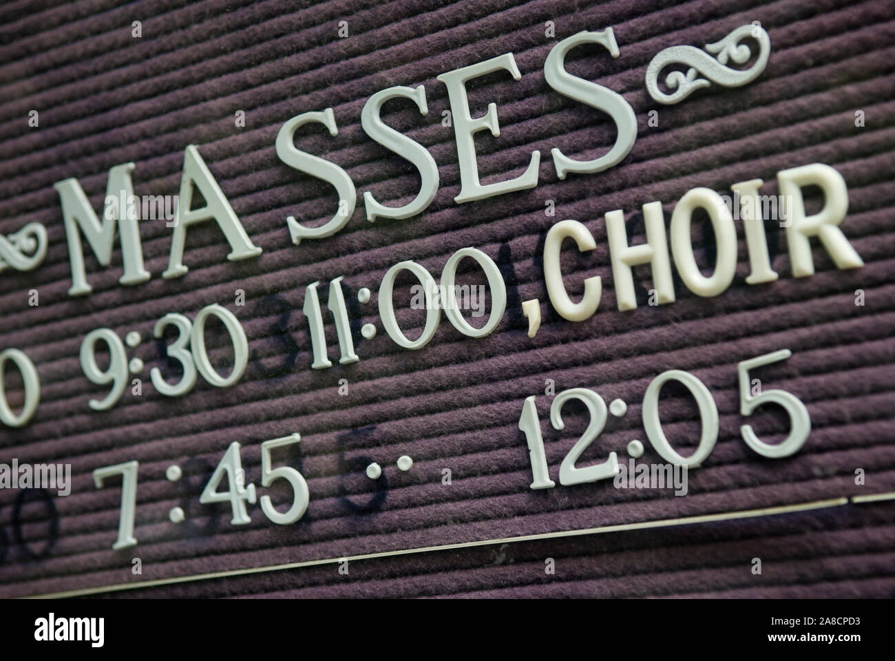 Close up of church sign listing times for masses and choir in old ...