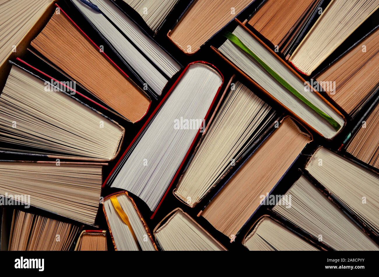Books. Lots of colourful thick open books stand on a dark background ...