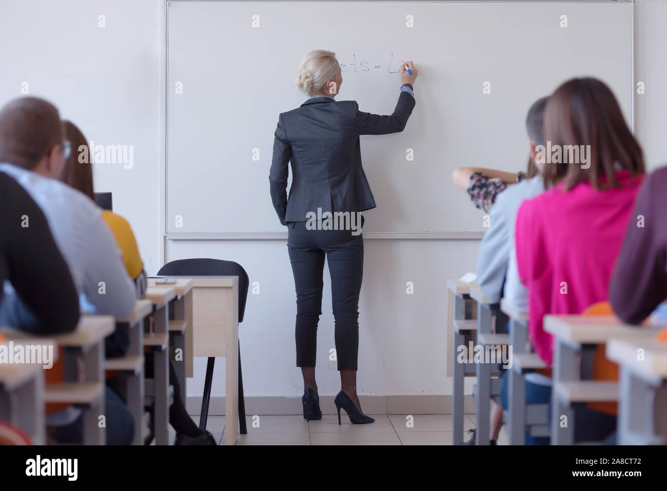 Female professor explain to students and interact with them in the ...