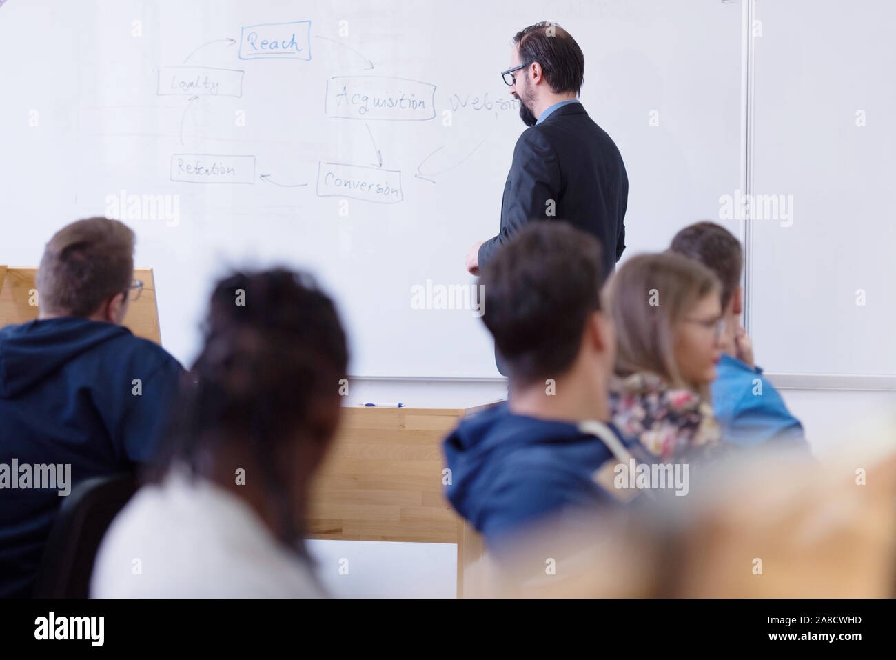 Group of students study with professor in modern school classroom. Male ...