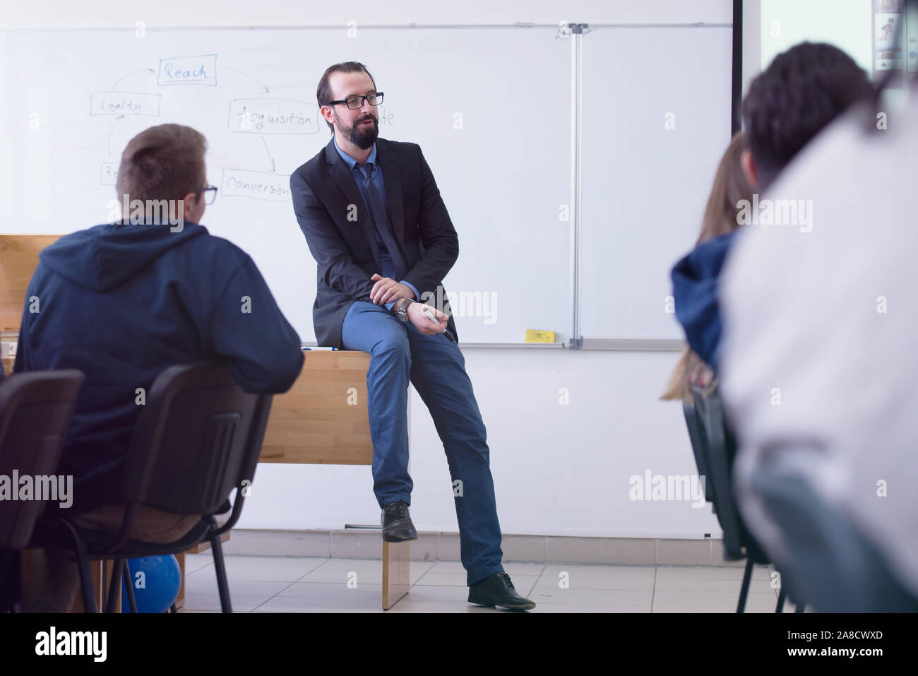 Group of students study with professor in modern school classroom. Male ...