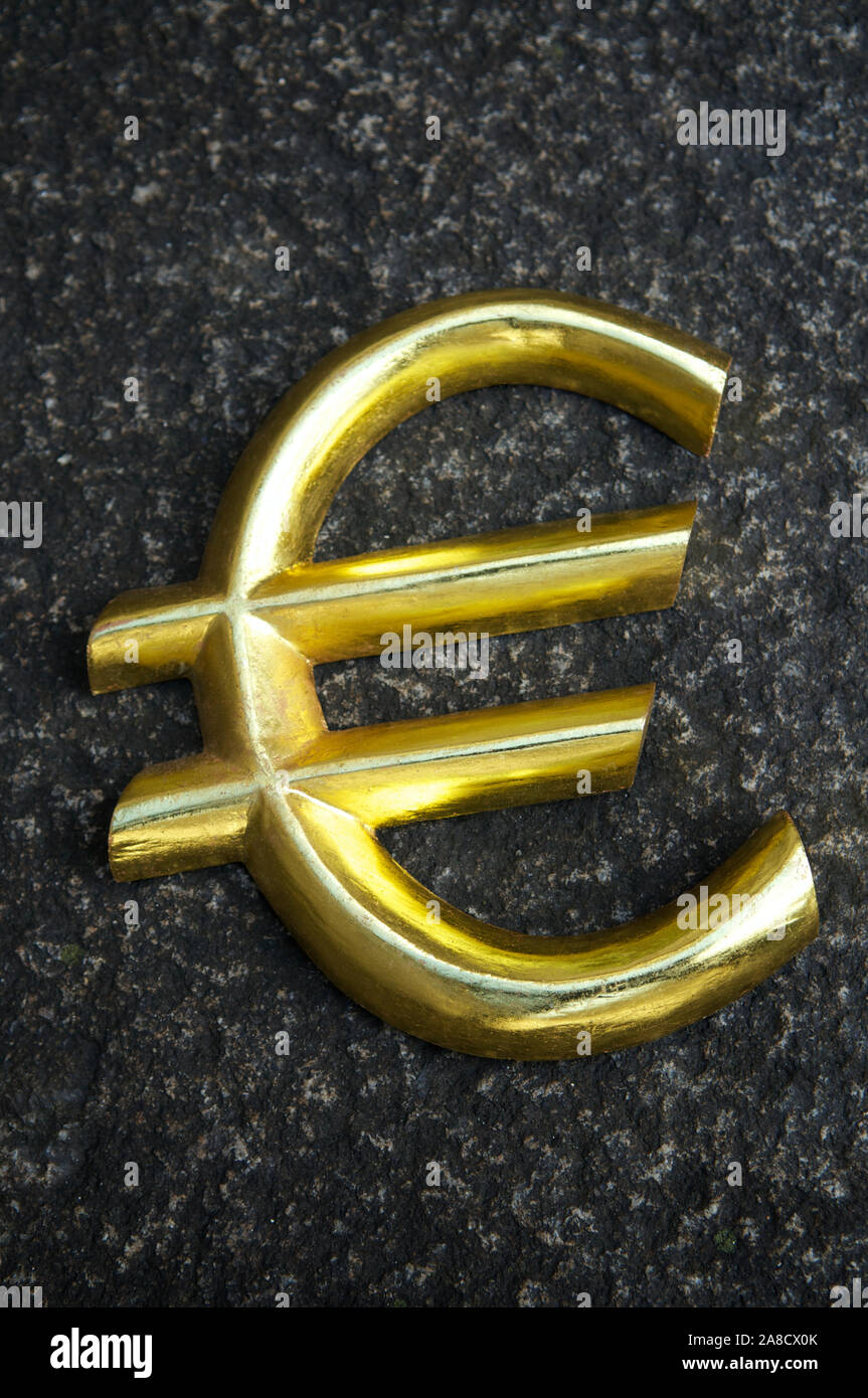 Golden euro symbol siting outdoors on gritty stone background Stock ...