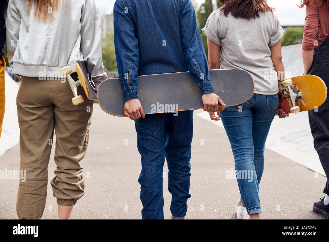Skateboard walking behind hi-res stock photography and images - Alamy