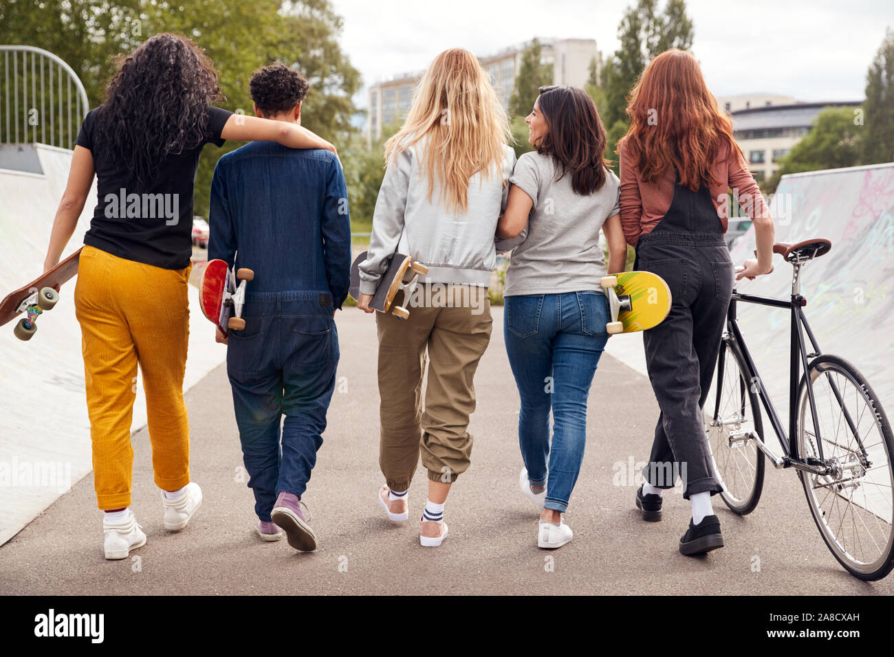 Skateboard walking behind hi-res stock photography and images - Alamy