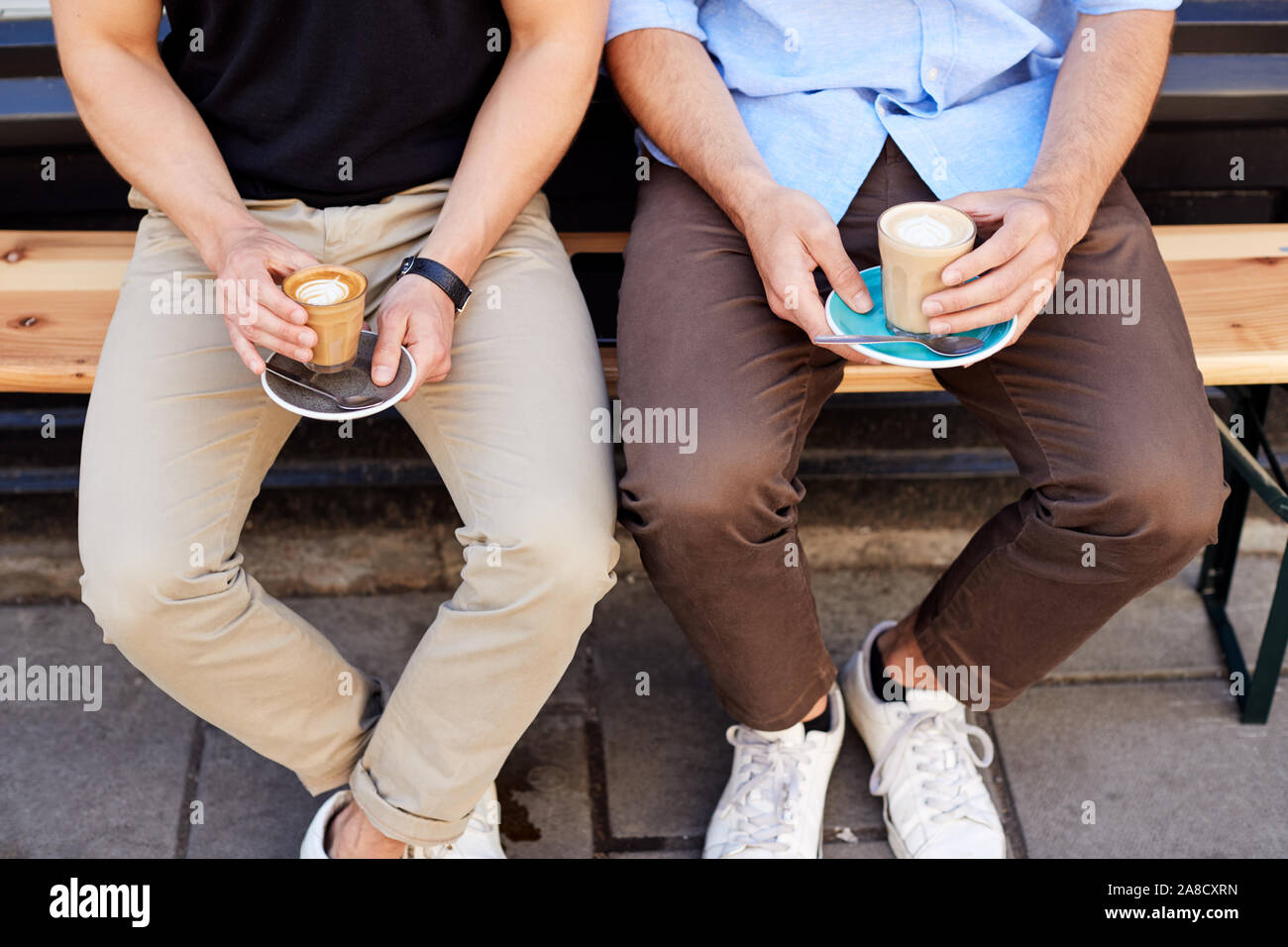 Close Up Of Two Men Sitting Outside Coffee Shop Drinking Coffee Stock ...