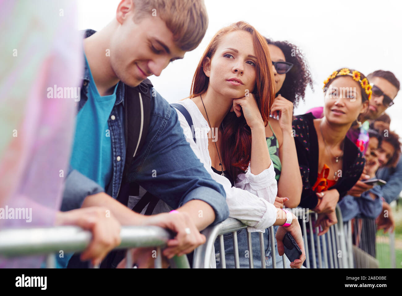 Group Of Young Friends Waiting Behind Barrier At Entrance To Music ...