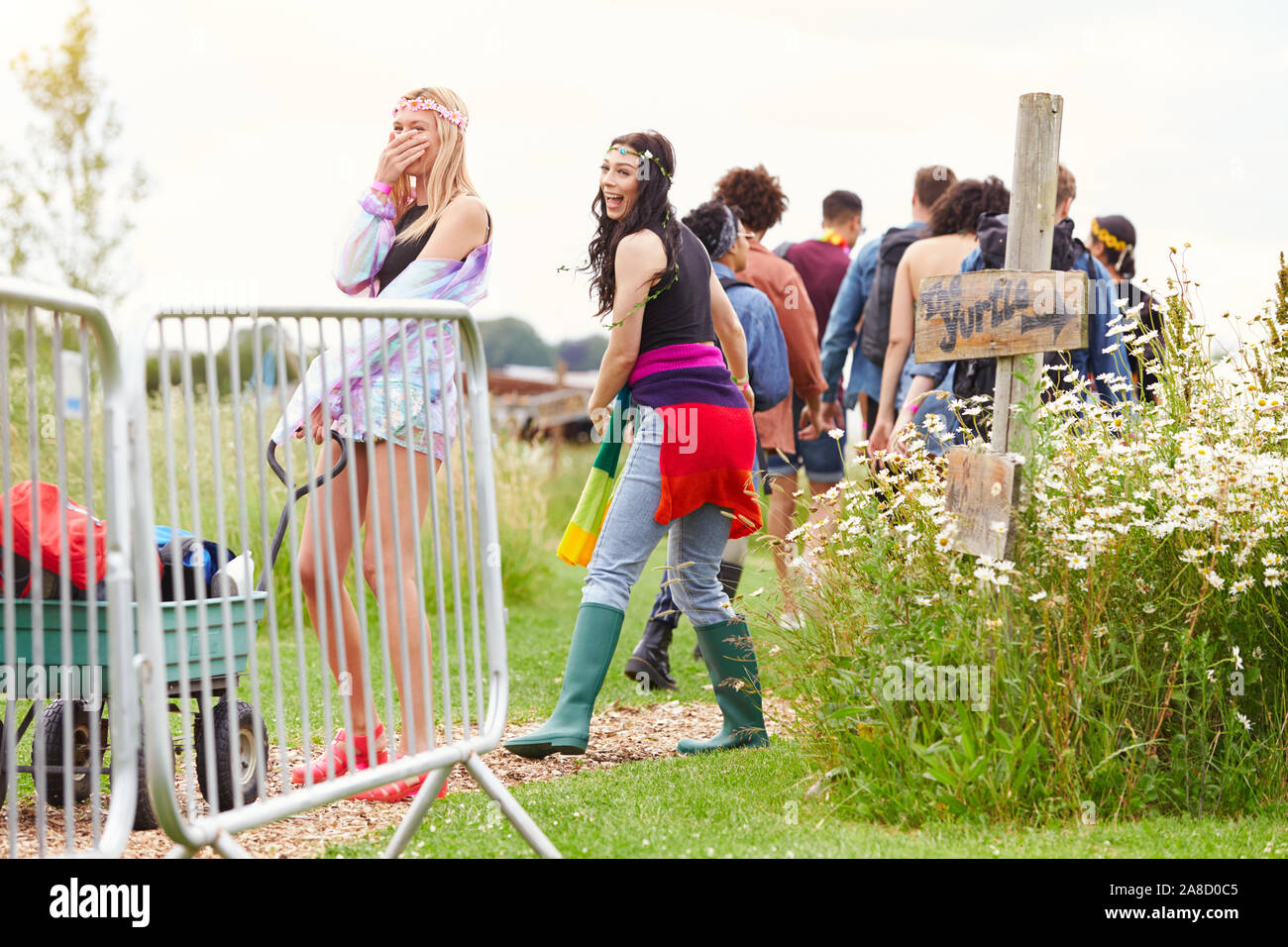 Group Of Young Friends Waiting Behind Barrier At Entrance To Music ...