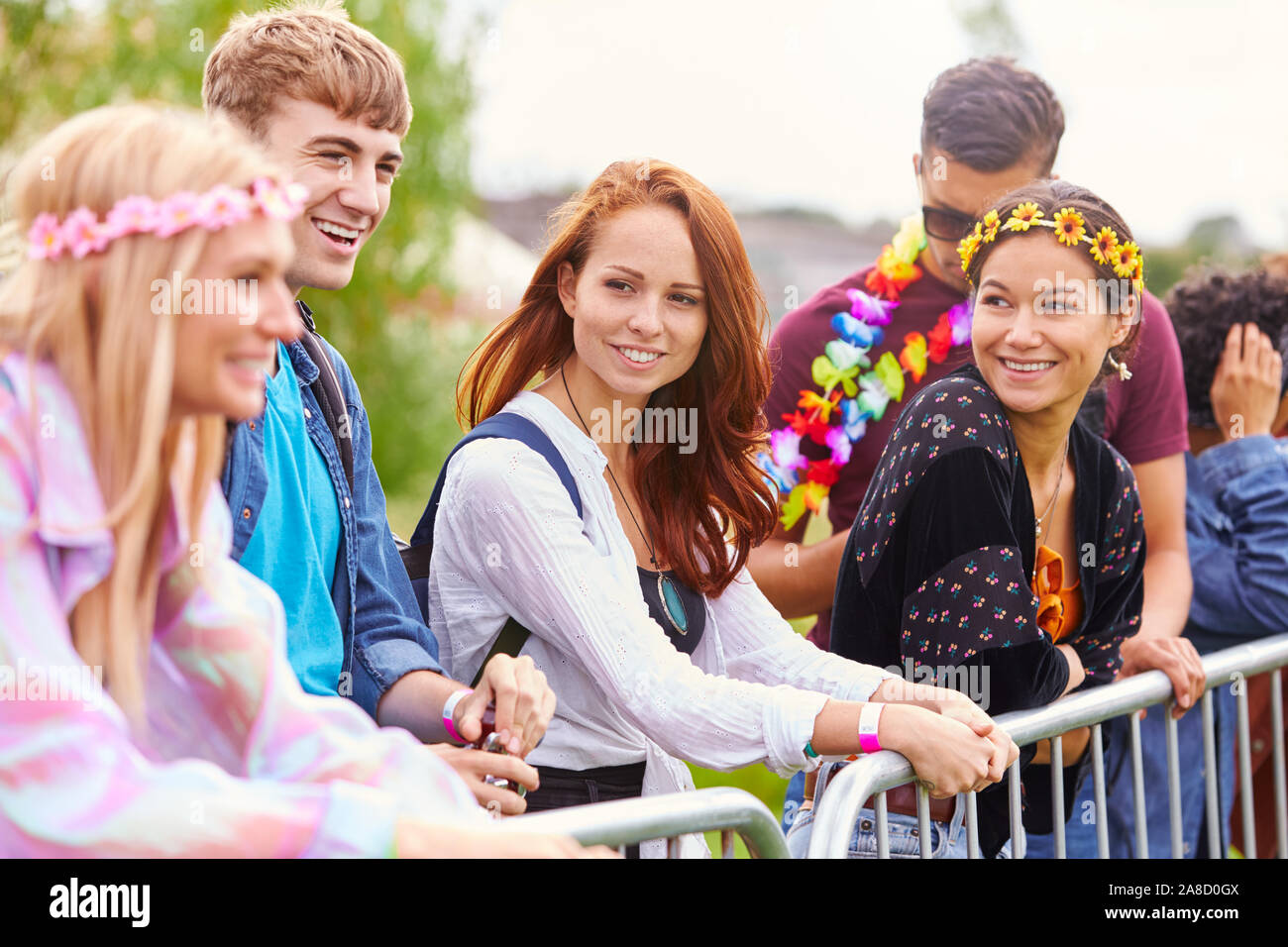 Group Of Young Friends Waiting Behind Barrier At Entrance To Music ...