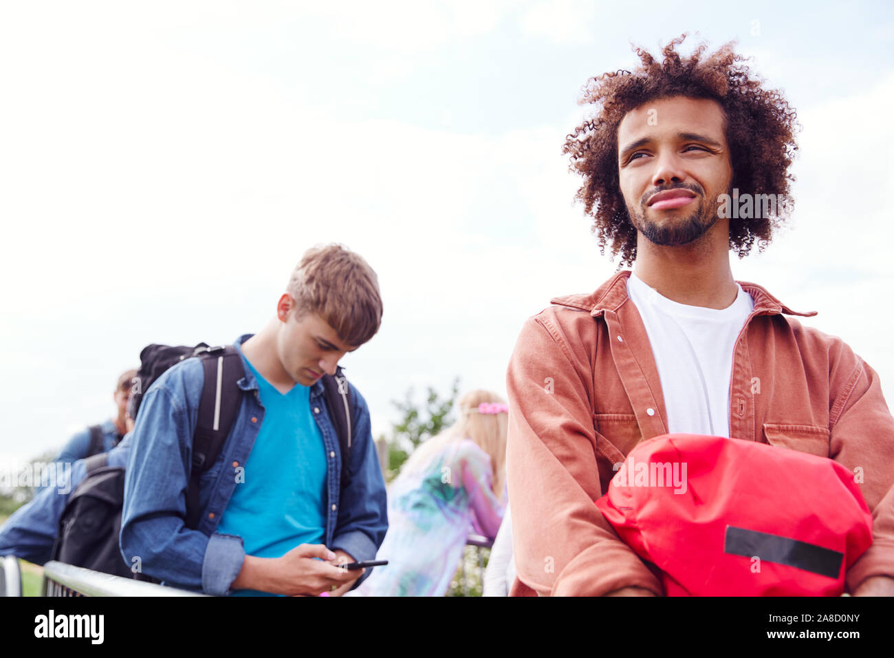 Young Man Waiting Behind Barrier At Entrance To Music Festival Site ...