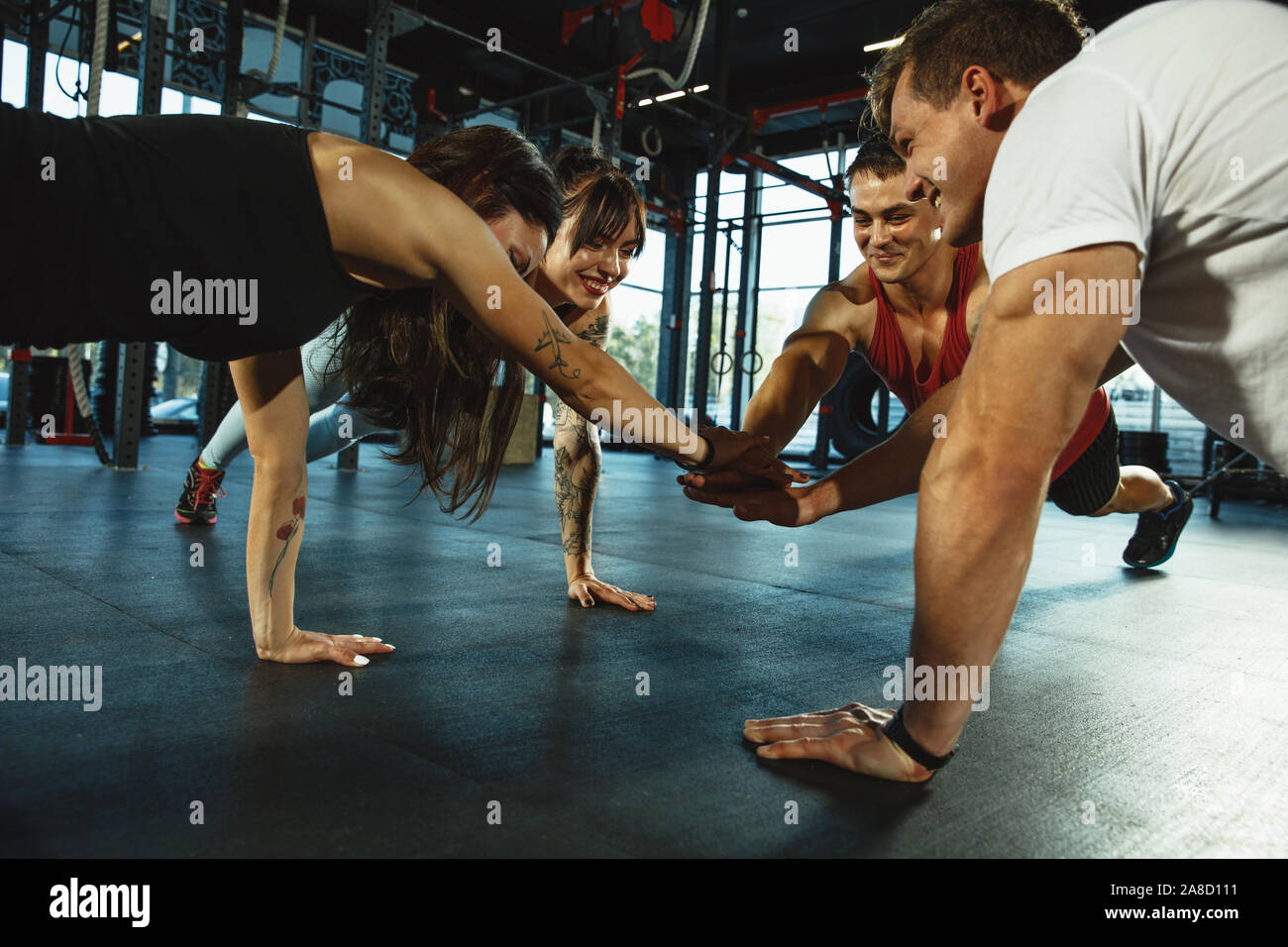A group of muscular athletes doing workout at the gym. Gymnastics ...