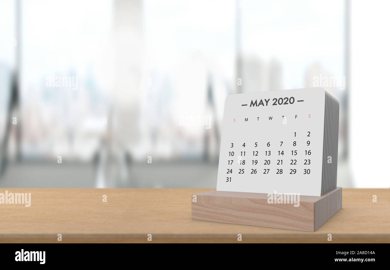 May 2020 calendar on a brown wooden table In front of shiny modern ...
