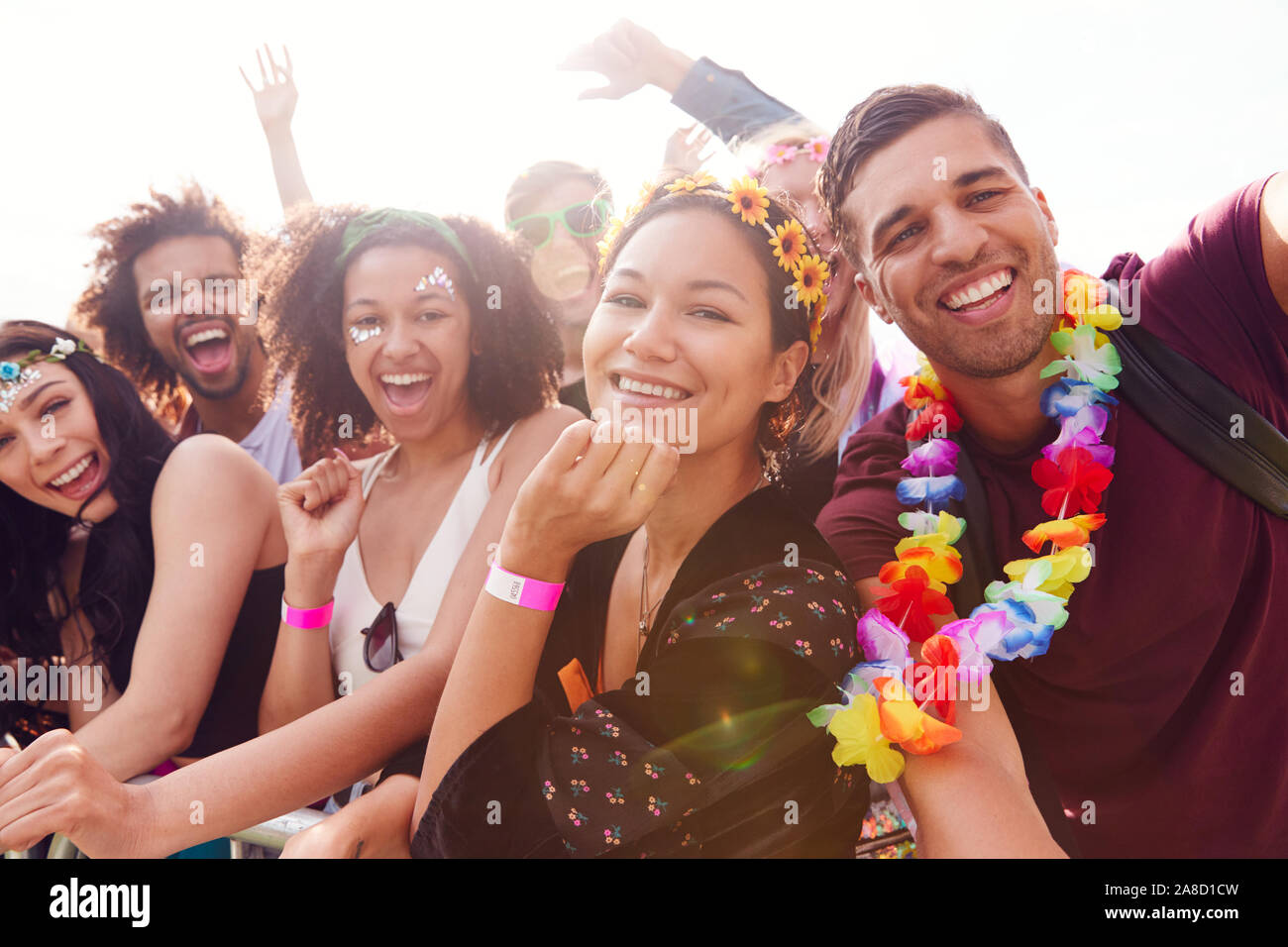 Portrait Of Young Friends In Audience Behind Barrier At Outdoor Music ...