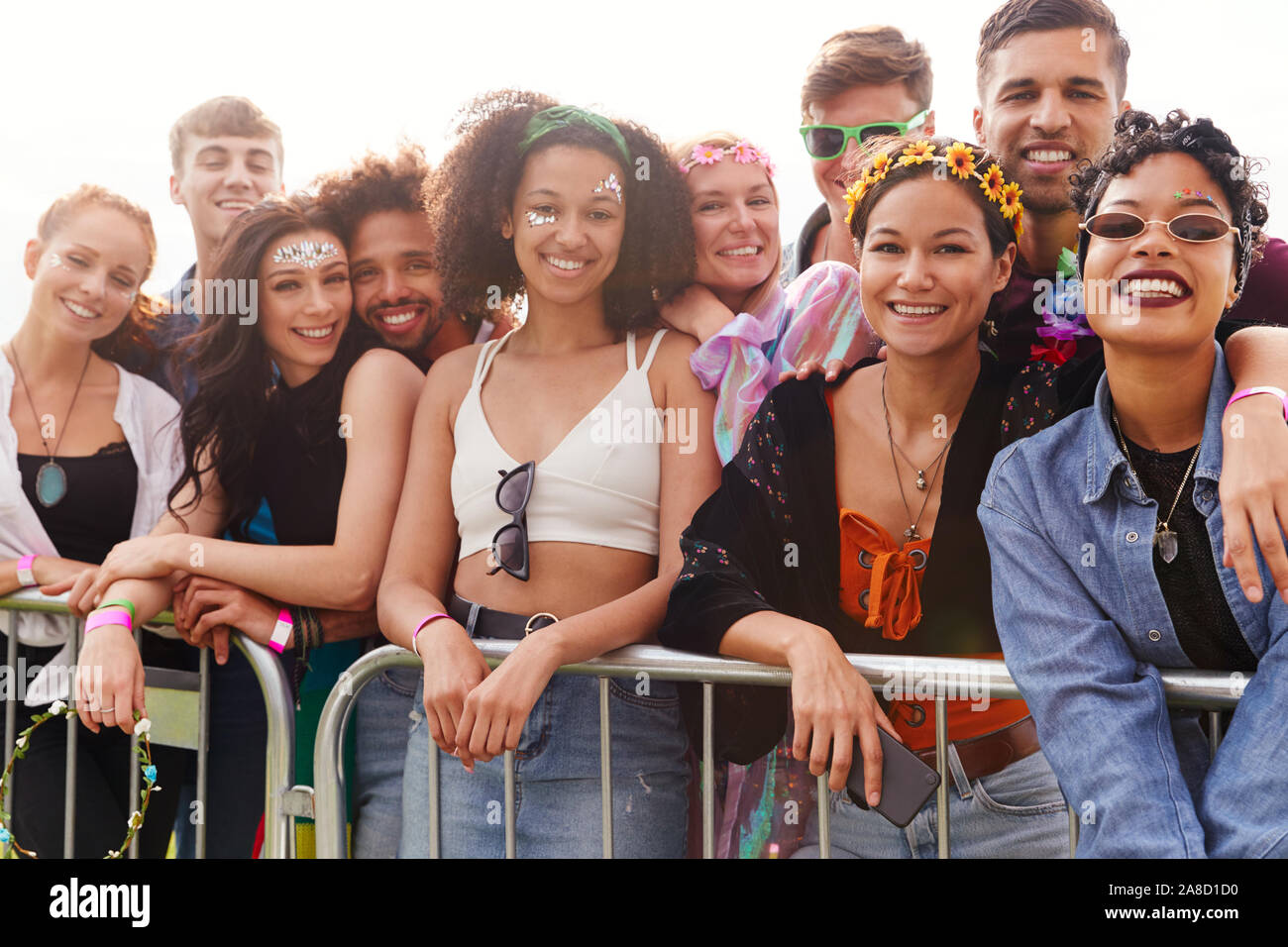 Portrait Of Young Friends In Audience Behind Barrier At Outdoor Music ...