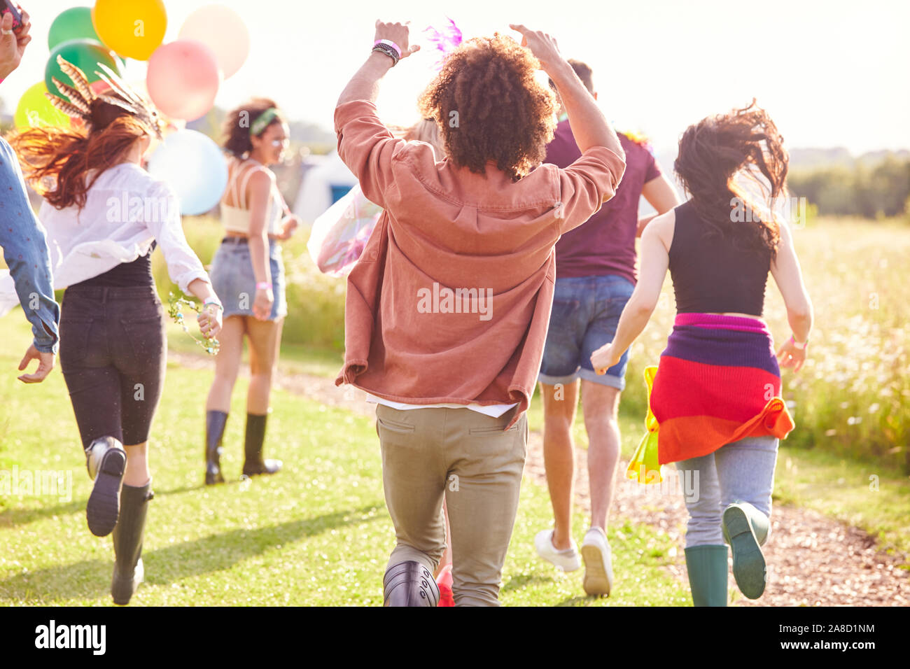 Rear View Of Group Of Friends Walking Back To Tent After Outdoor Music ...