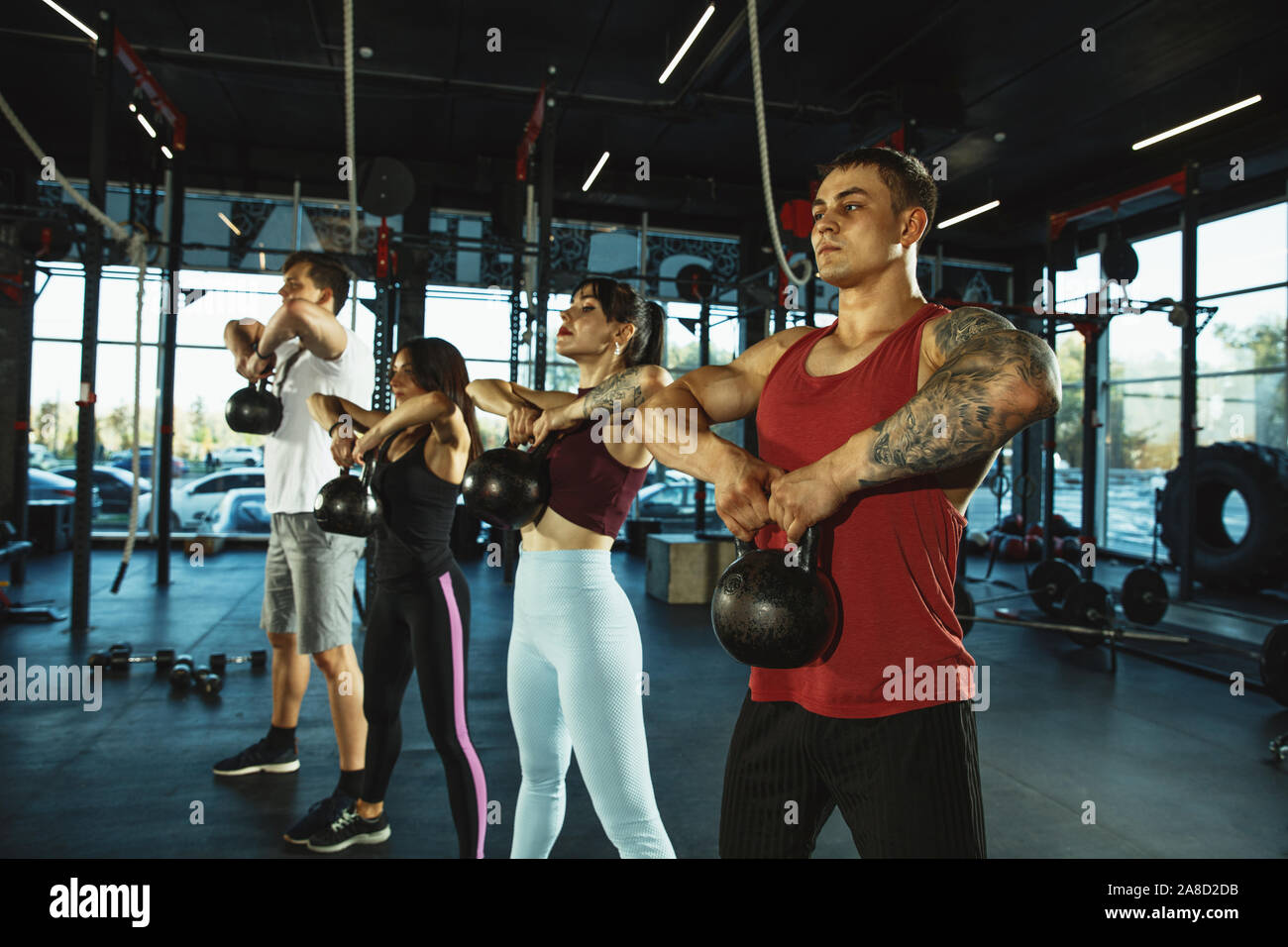 A group of muscular athletes doing workout at the gym. Gymnastics ...