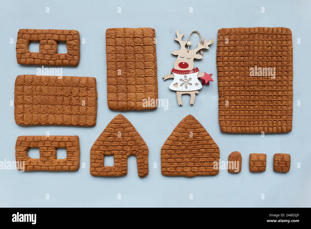 Making gingerbread house for Christmas. Parts of house on gray wooden ...