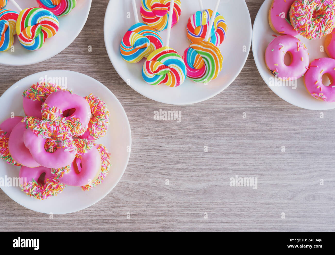 Top view, sweets food on wooden table. Glazed mini donuts and candy ...