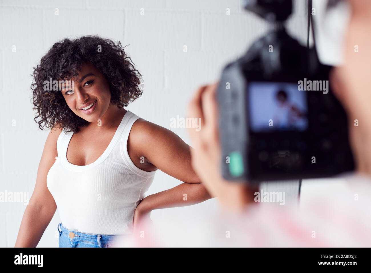 Model Posing For Female Photographer In Studio Portrait Session Stock ...