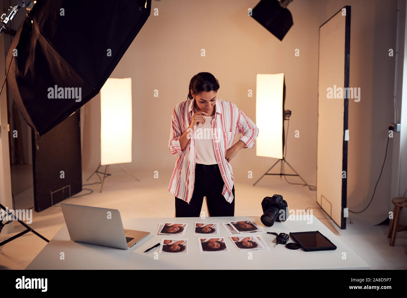 Female Photographer Editing Images From Photo Shoot In Studio Stock ...