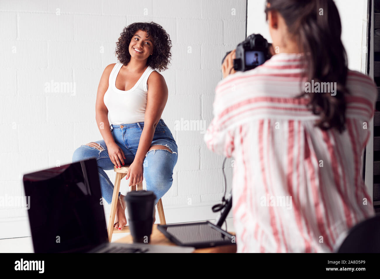 Model Posing For Female Photographer In Studio Portrait Session Stock ...
