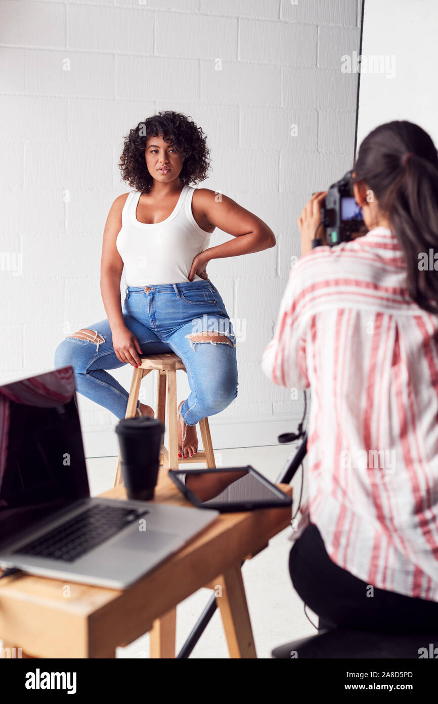 Model Posing For Female Photographer In Studio Portrait Session Stock ...