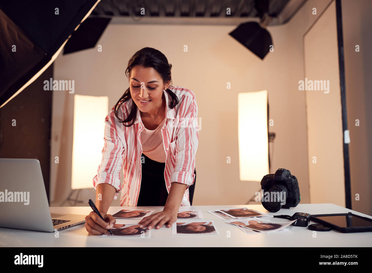 Female Photographer Editing Images From Photo Shoot In Studio Stock ...