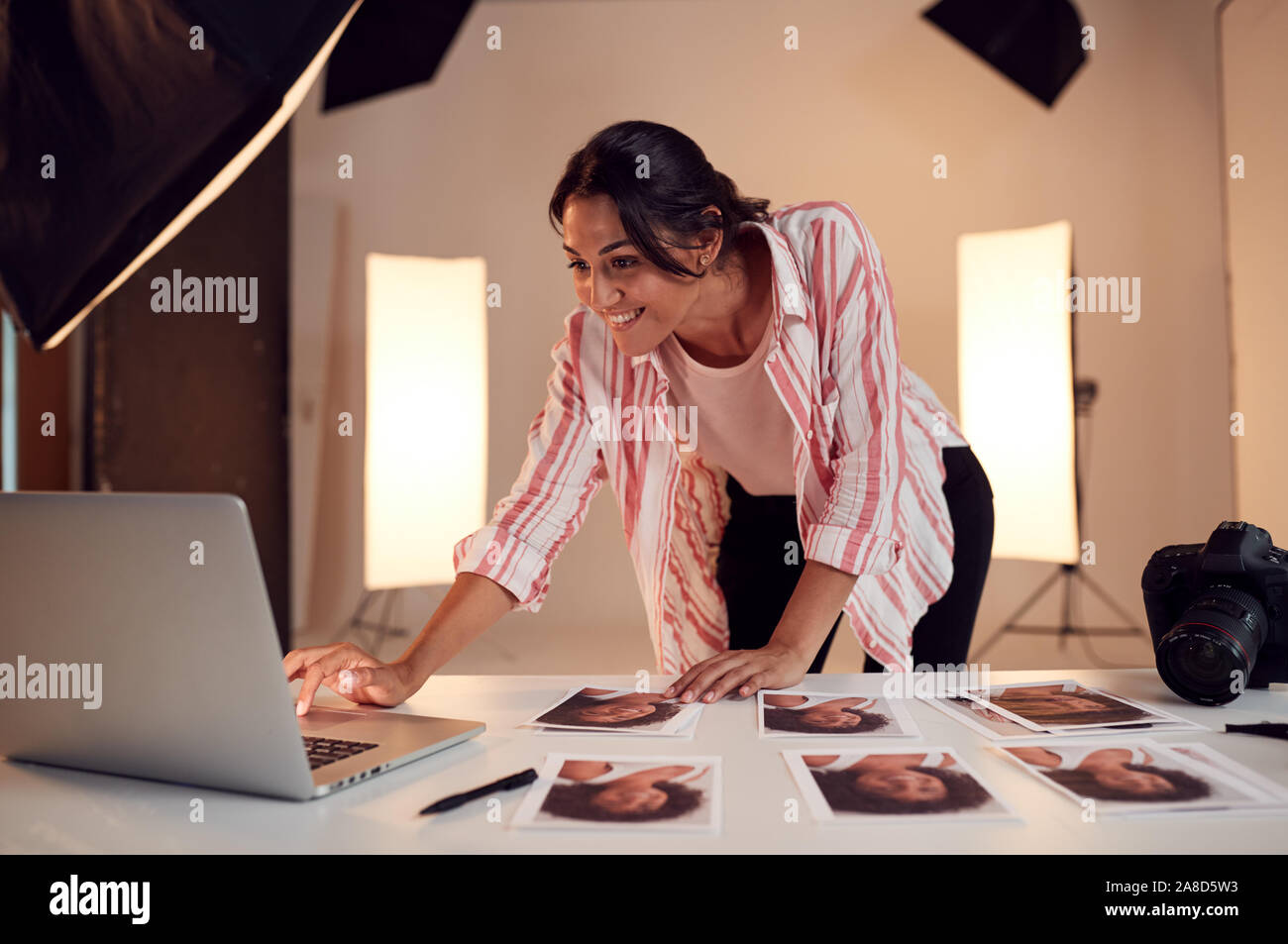 Female Photographer Editing Images From Photo Shoot In Studio Stock ...