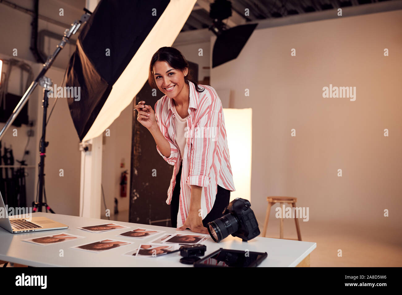 Portrait Of Female Photographer Editing Images From Photo Shoot In ...