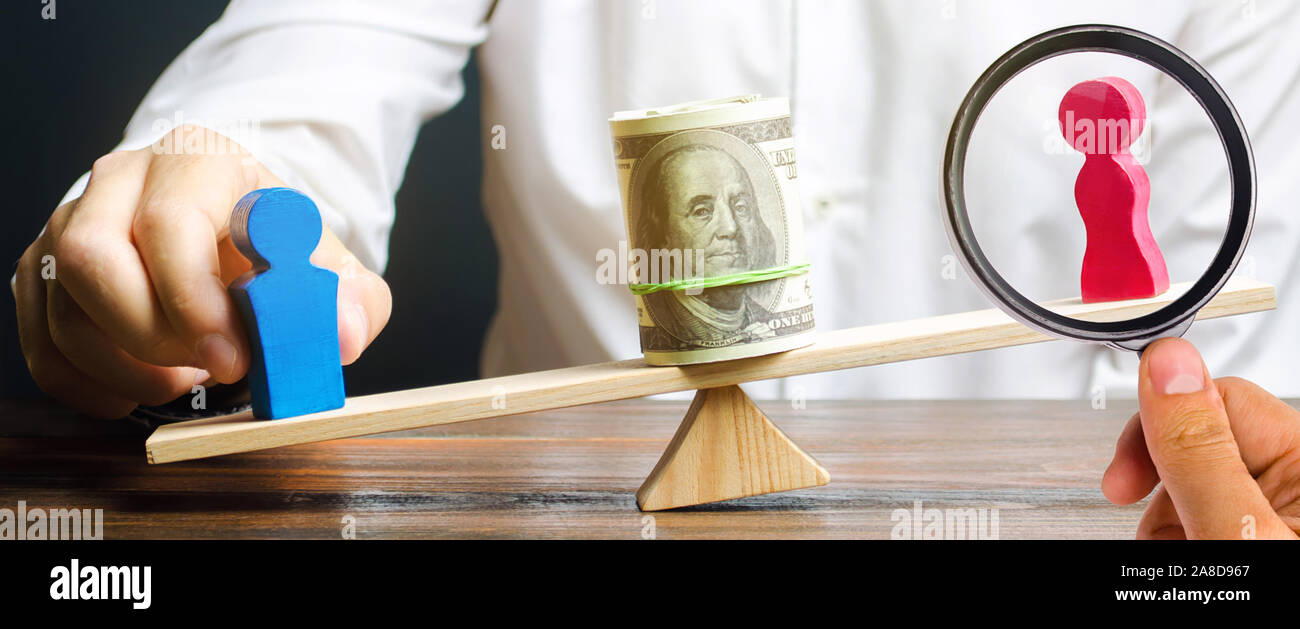 Wooden figures of man and women on the scales. Concept of gender pay ...