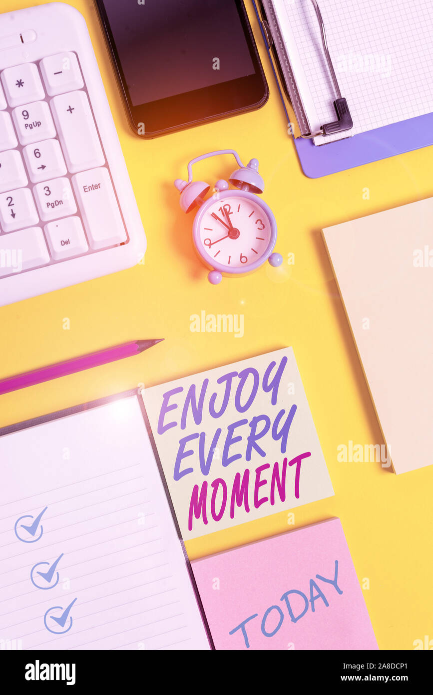 Writing note showing Enjoy Every Moment. Business concept for being ...