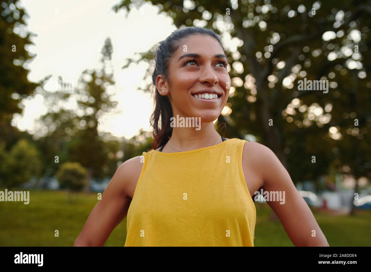Portrait of a smiling happy fit slim young woman looking motivated and ...