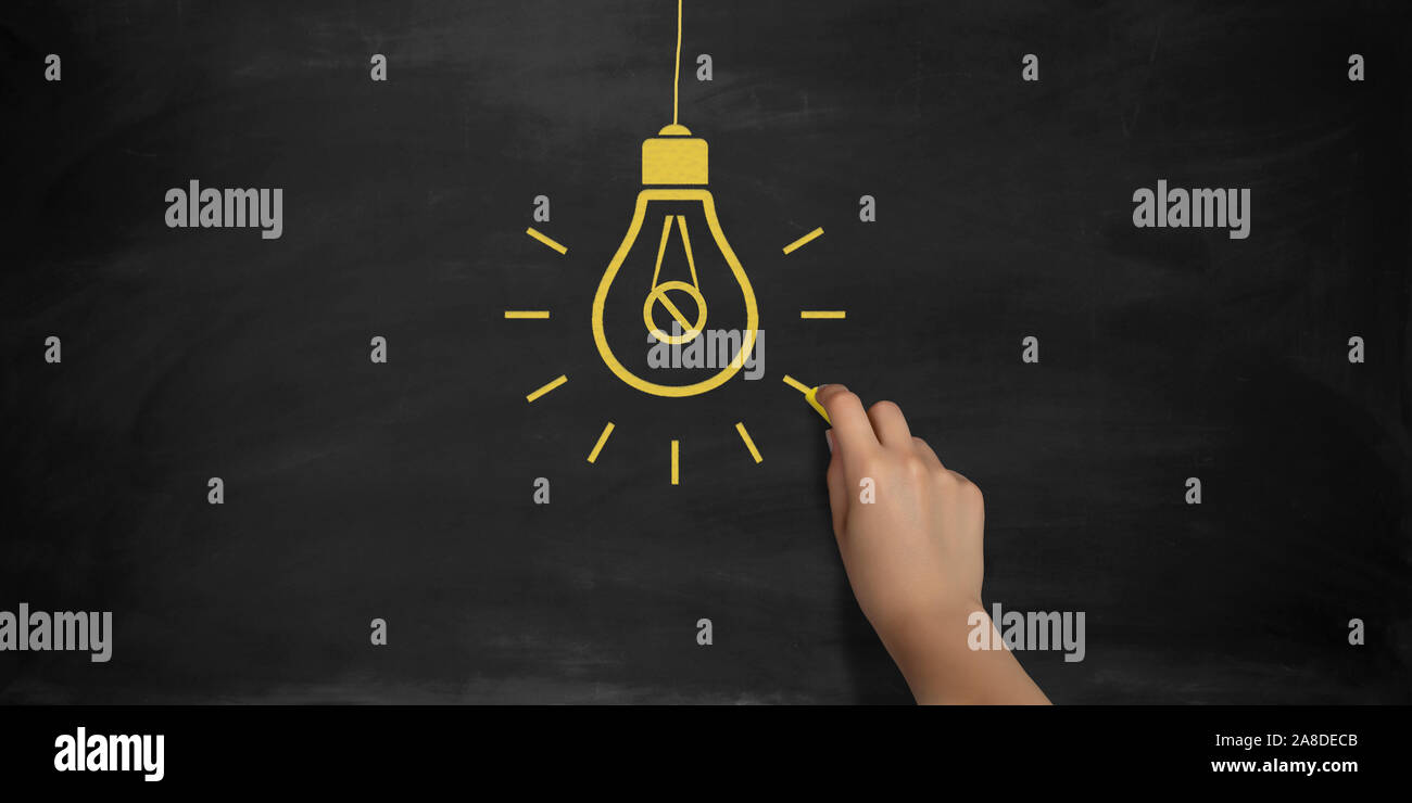 Warning Sign bulb drawing with a yellow chalk on blackboard by a female ...