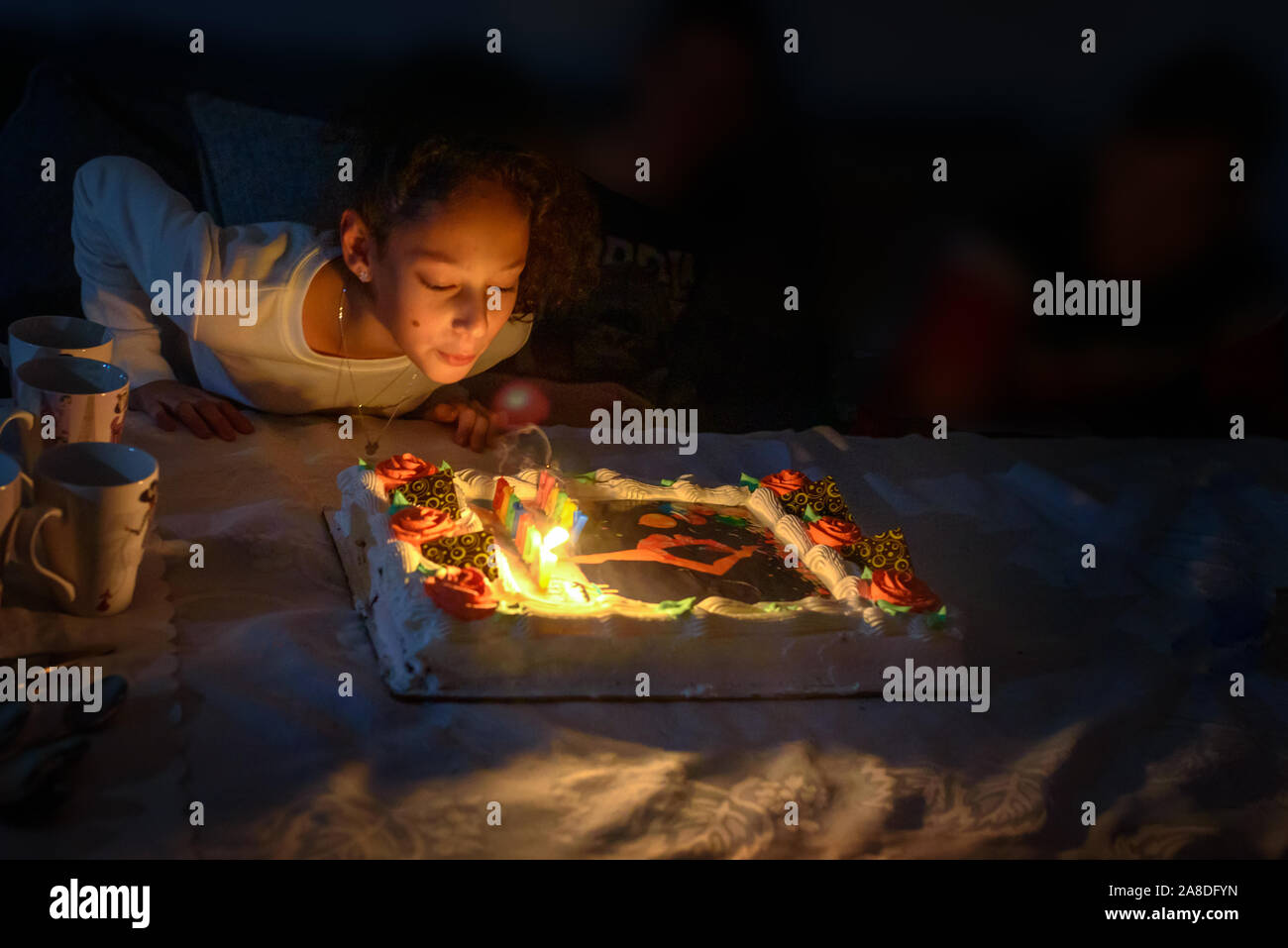 Adorable teen girl celebrating her birthday and blowing candles on ...