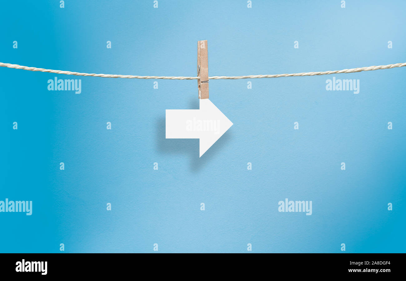 Cut out Arrow Symbol in white cut out paper on blue background. High ...