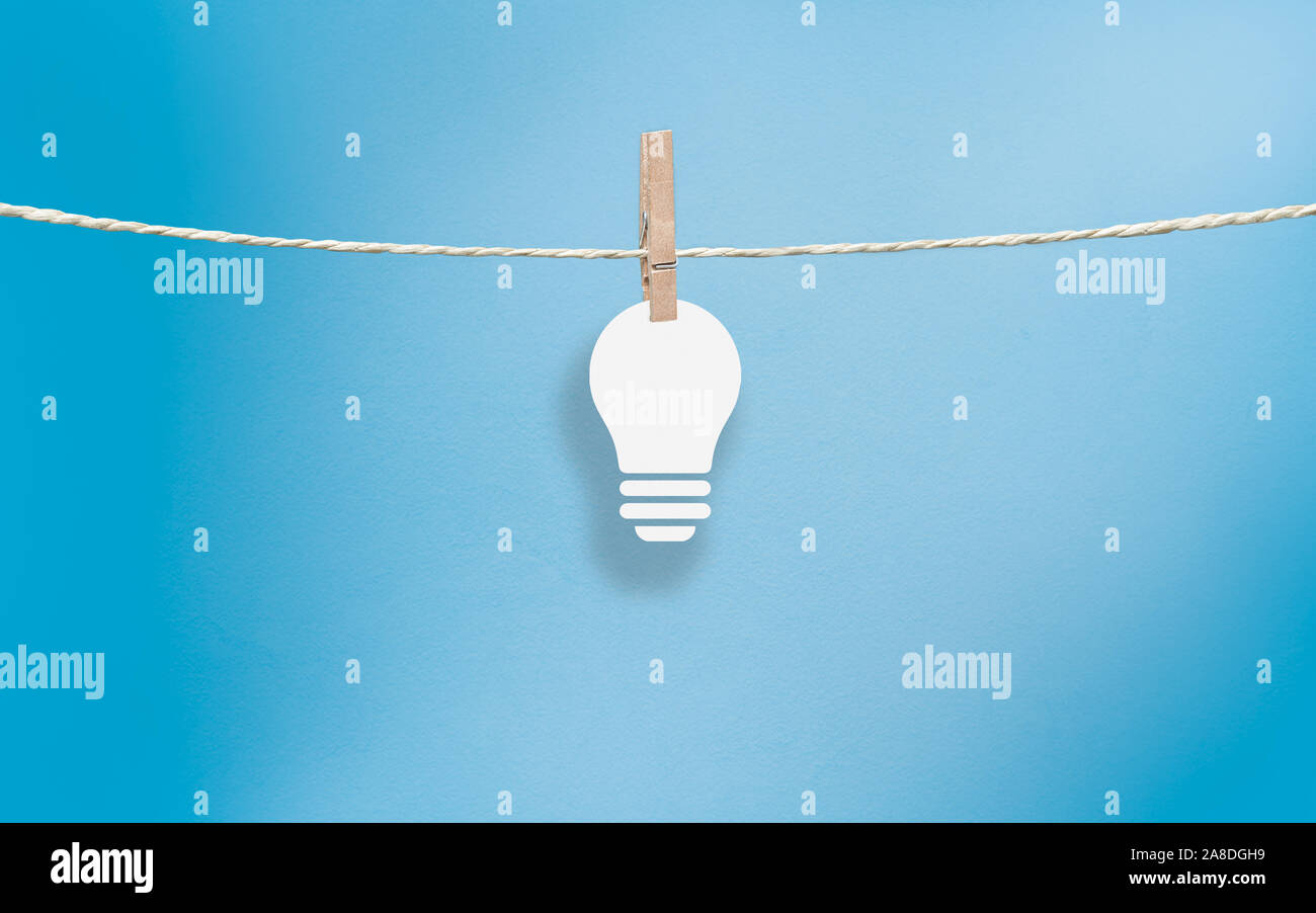 Cut out Light Bulb icon in white cut out paper on blue background. High ...