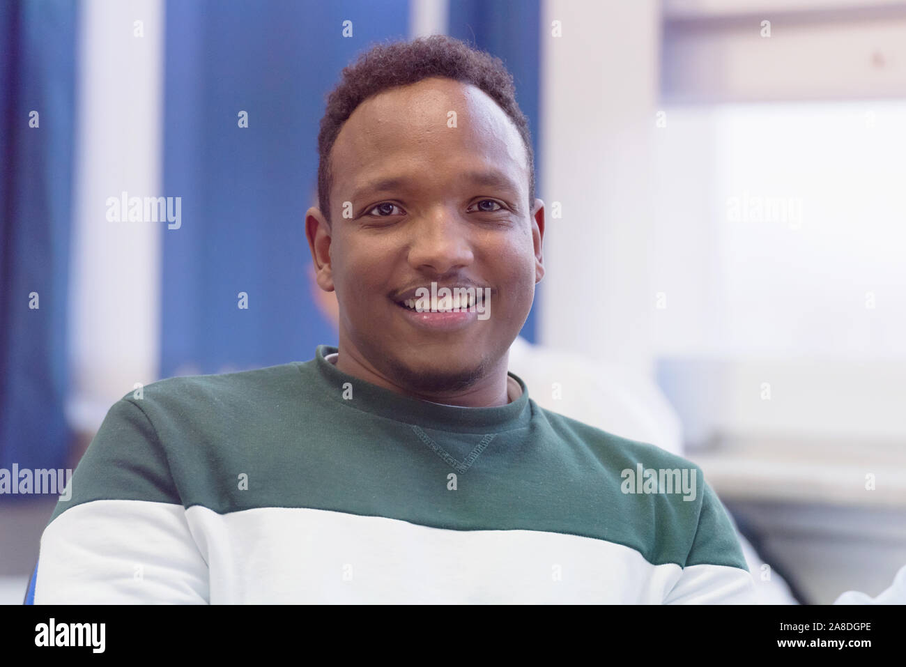 Smiling african american university male student in class sits at his ...