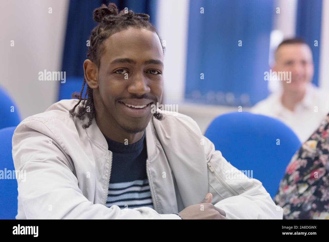 Smiling african american university male student in class sits at his ...