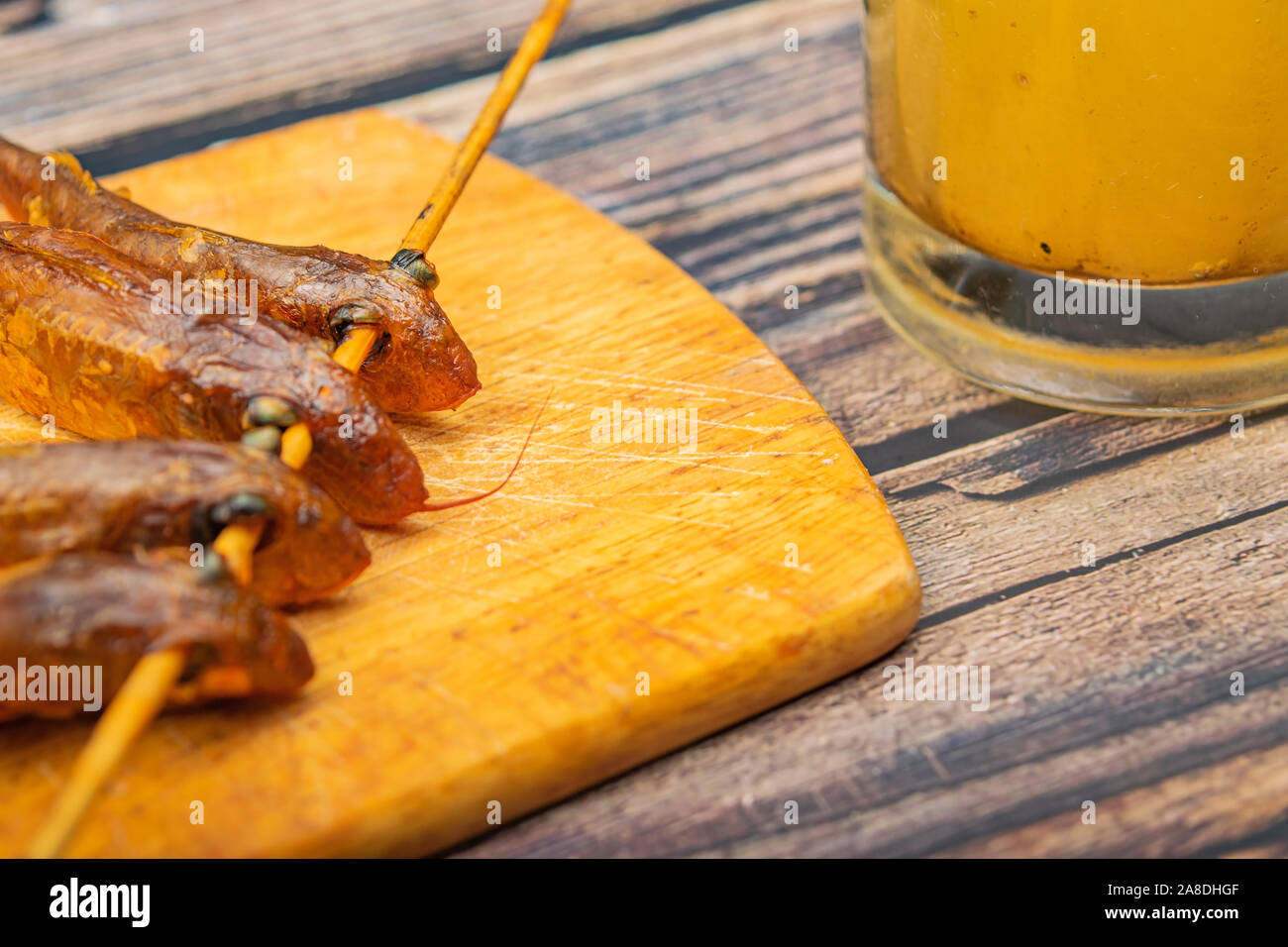Dried mullet on a wooden Board with a mug of beer on the table. Fish ...