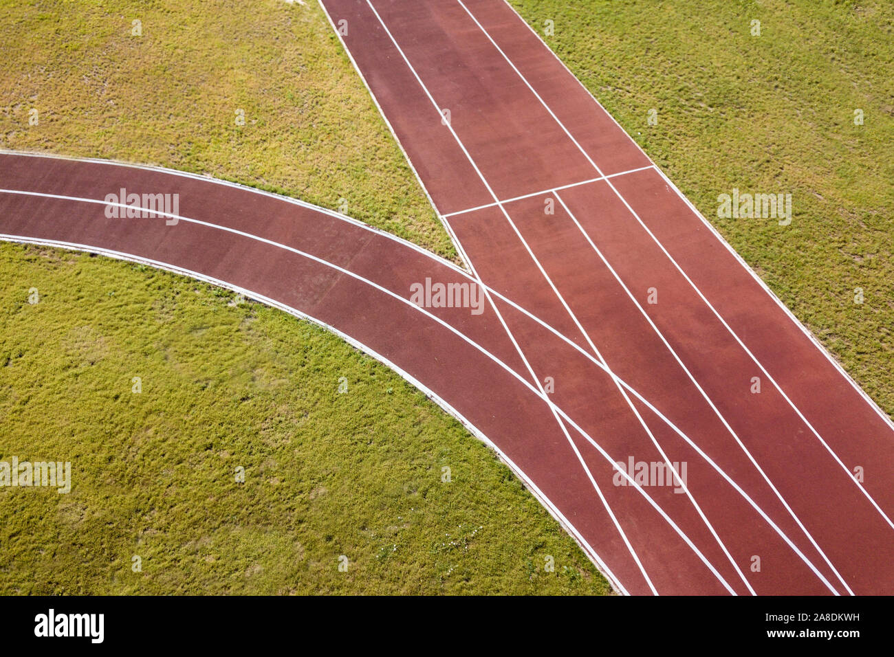 Top view of red running tracks and green grass lawn. Infrastructure for ...