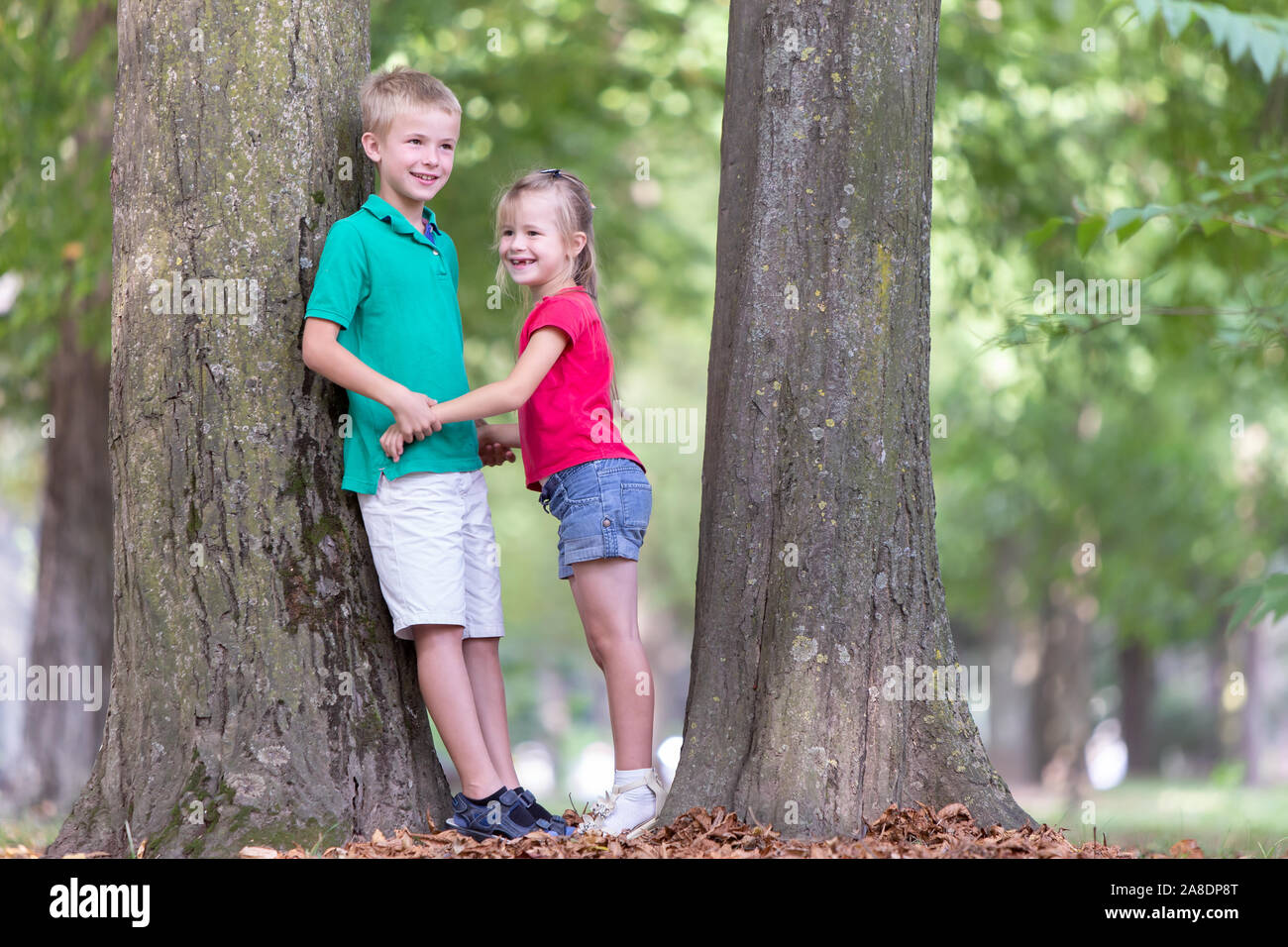 Portrait of two pretty cute children boy and girl standing near big ...