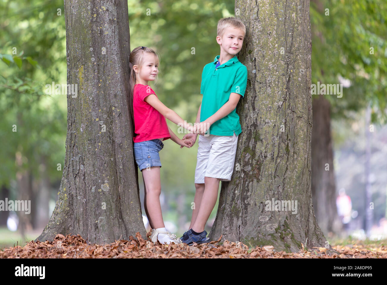 Portrait of two pretty cute children boy and girl standing near big ...