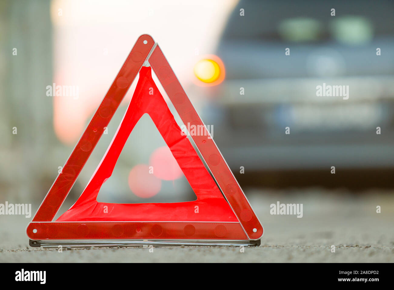 Red emergency triangle stop sign and broken car on a city street Stock ...