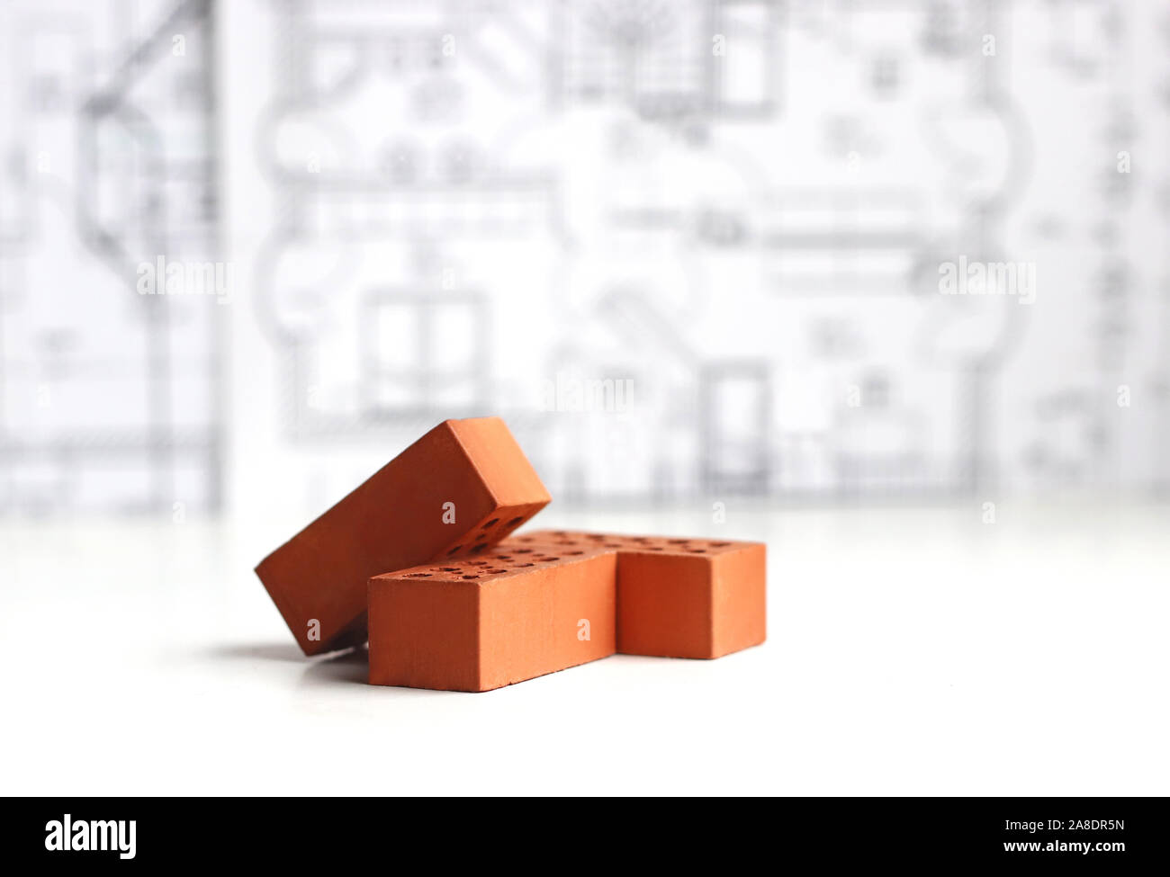 close-up of threee clay bricks with a defocused construction plan in ...