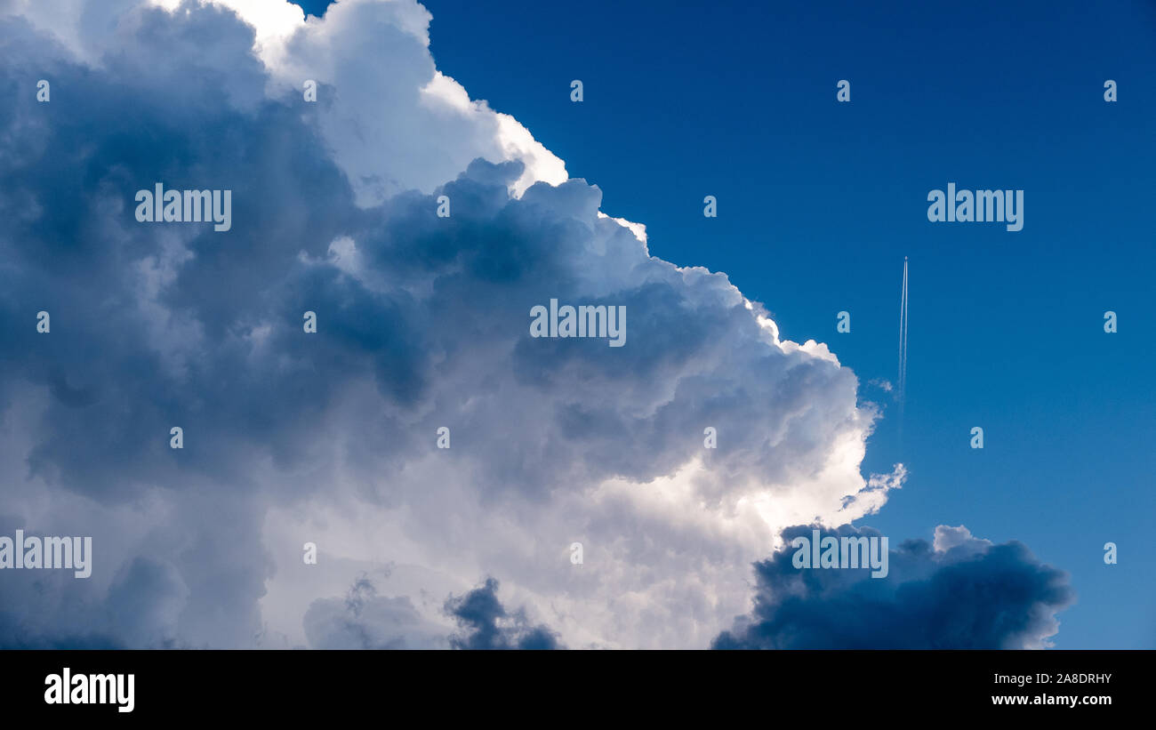 Jet with Contrail emerges from Thunderhead Stock Photo - Alamy