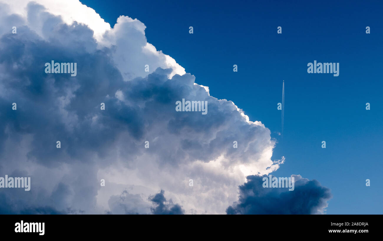 Jet with Contrail emerges from Thunderhead Stock Photo - Alamy