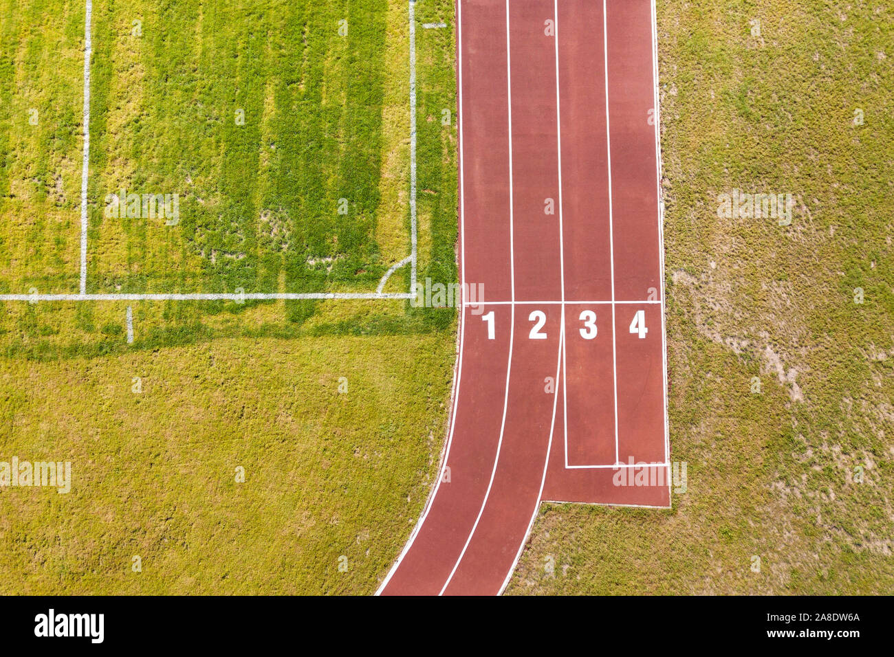 Top view of red running tracks and green grass lawn. Infrastructure for ...