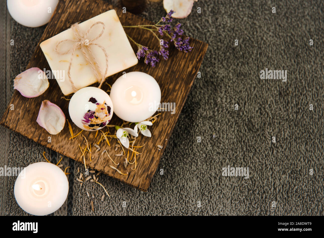 Various relaxation bath products on natural wood tray: creamy bath bomb ...