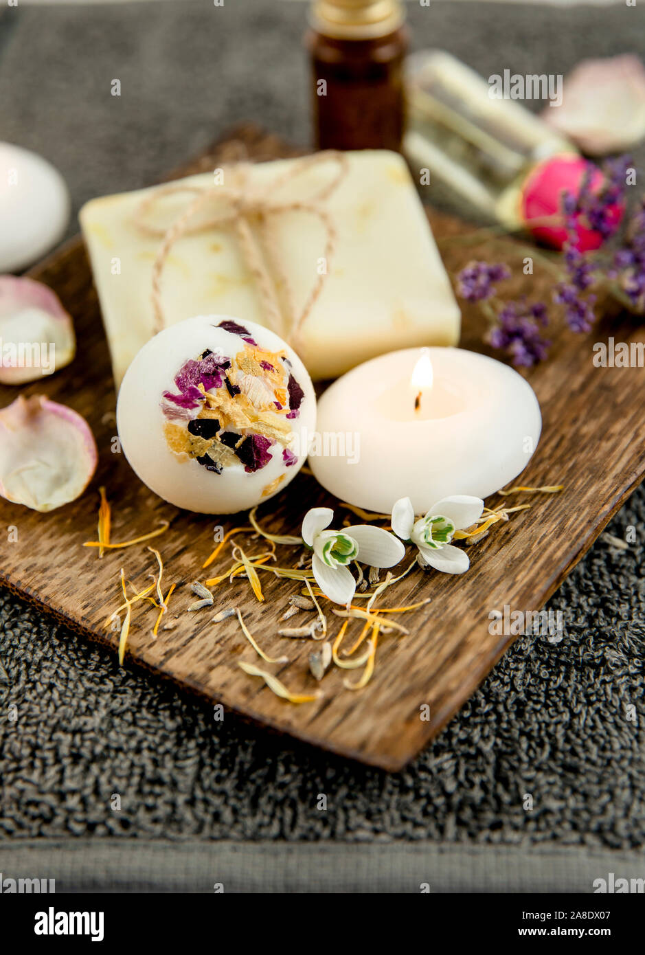 Various spa bath products on brown wooden tray creamy bath bomb ...