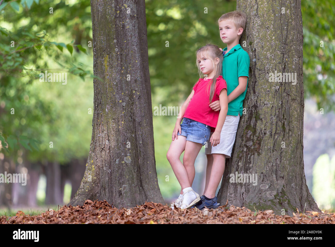 Portrait of two pretty cute children boy and girl standing near big ...