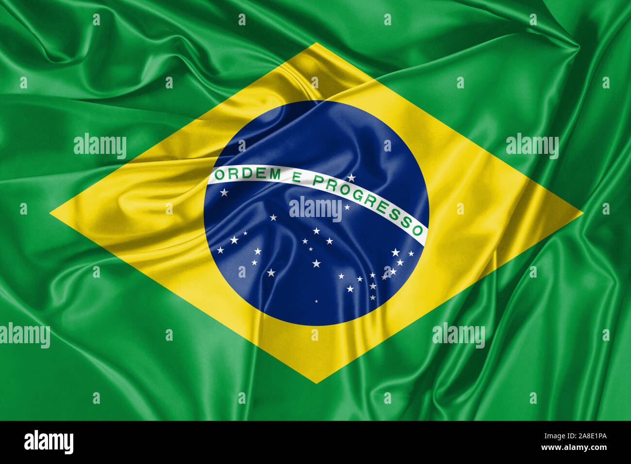 Shiny crippled Brazil flag is laying on a surface. Realistic ...